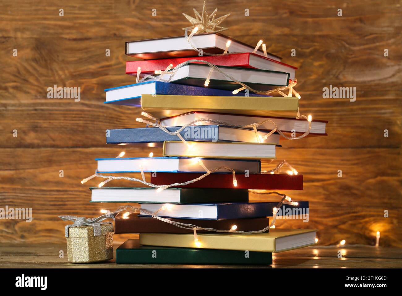 Stack of books and lights on wooden background Stock Photo - Alamy
