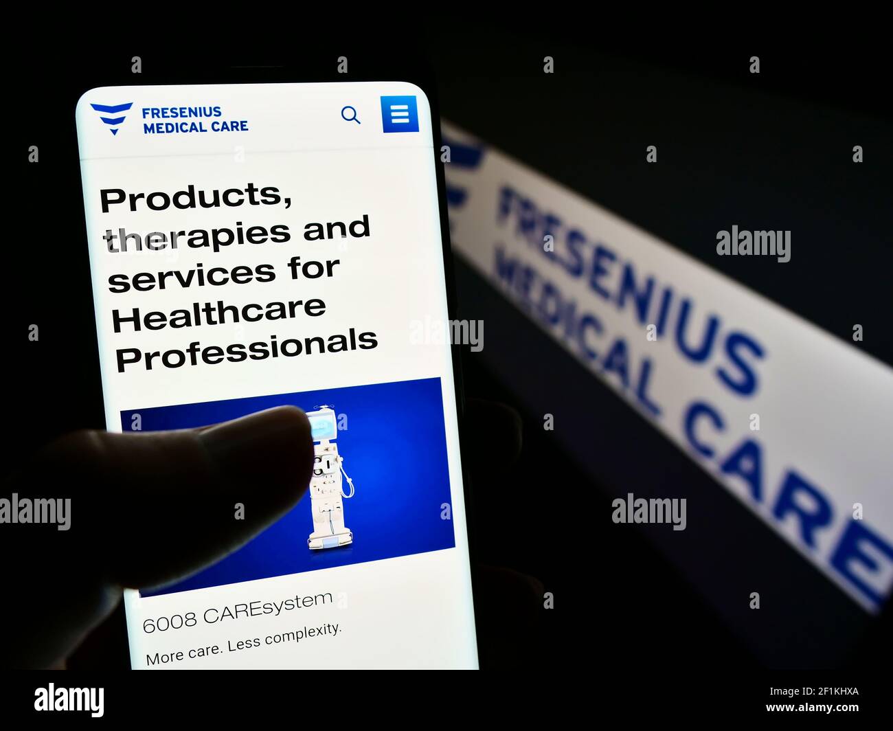 Person holding cellphone with webpage of German dialysis company ...