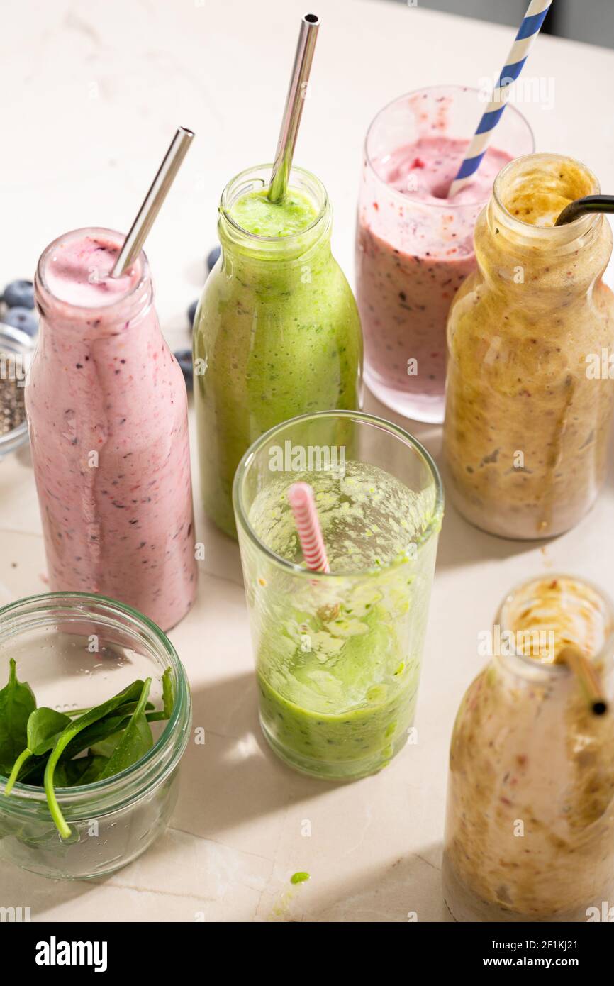 Various healthy summer smoothie on light surface Stock Photo - Alamy