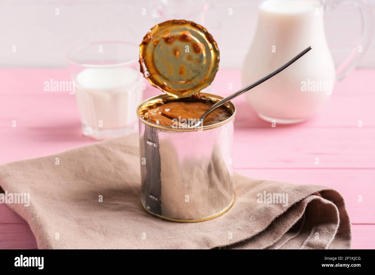 Tin can of boiled condensed milk on color wooden background Stock Photo ...