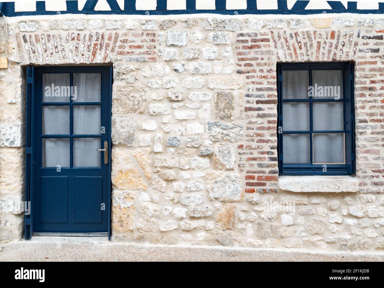 Typical stone house facade in Normandy in France with blue doors and ...
