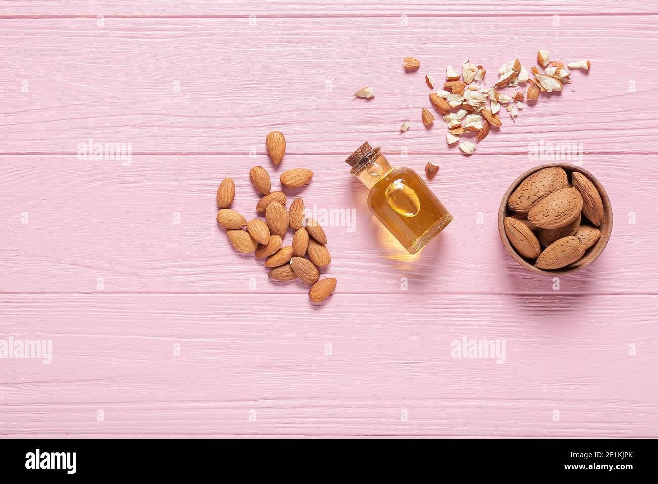 Composition with almond oil on color wooden background Stock Photo - Alamy