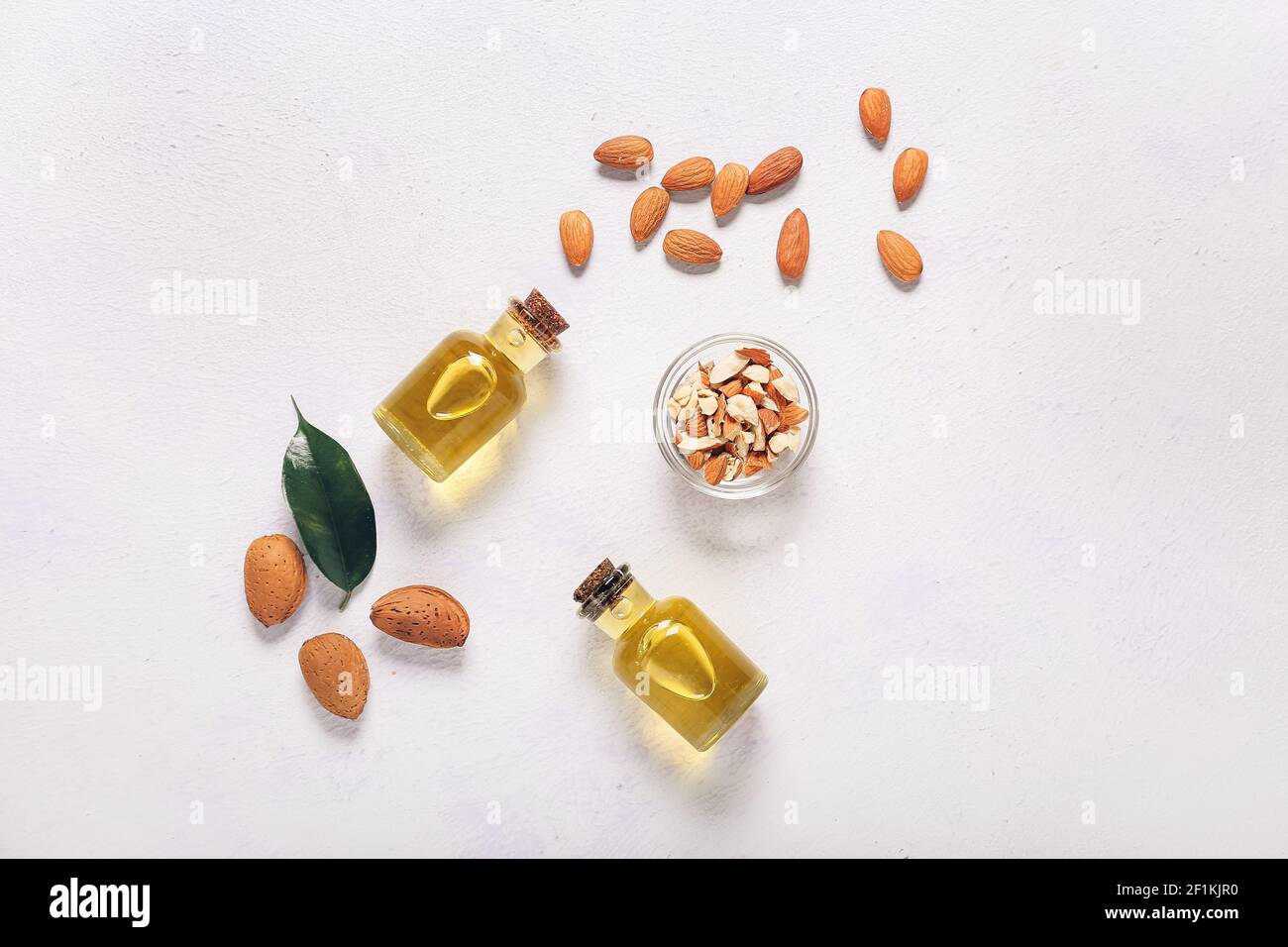 Composition with almond oil on light background Stock Photo - Alamy
