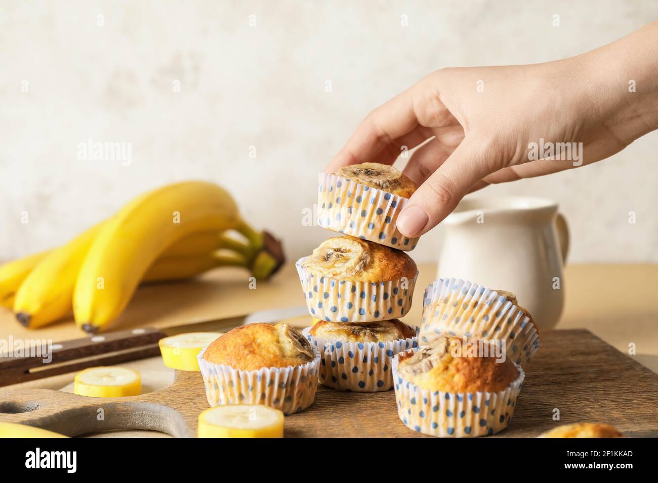 Female hand with tasty banana muffins on color table Stock Photo - Alamy