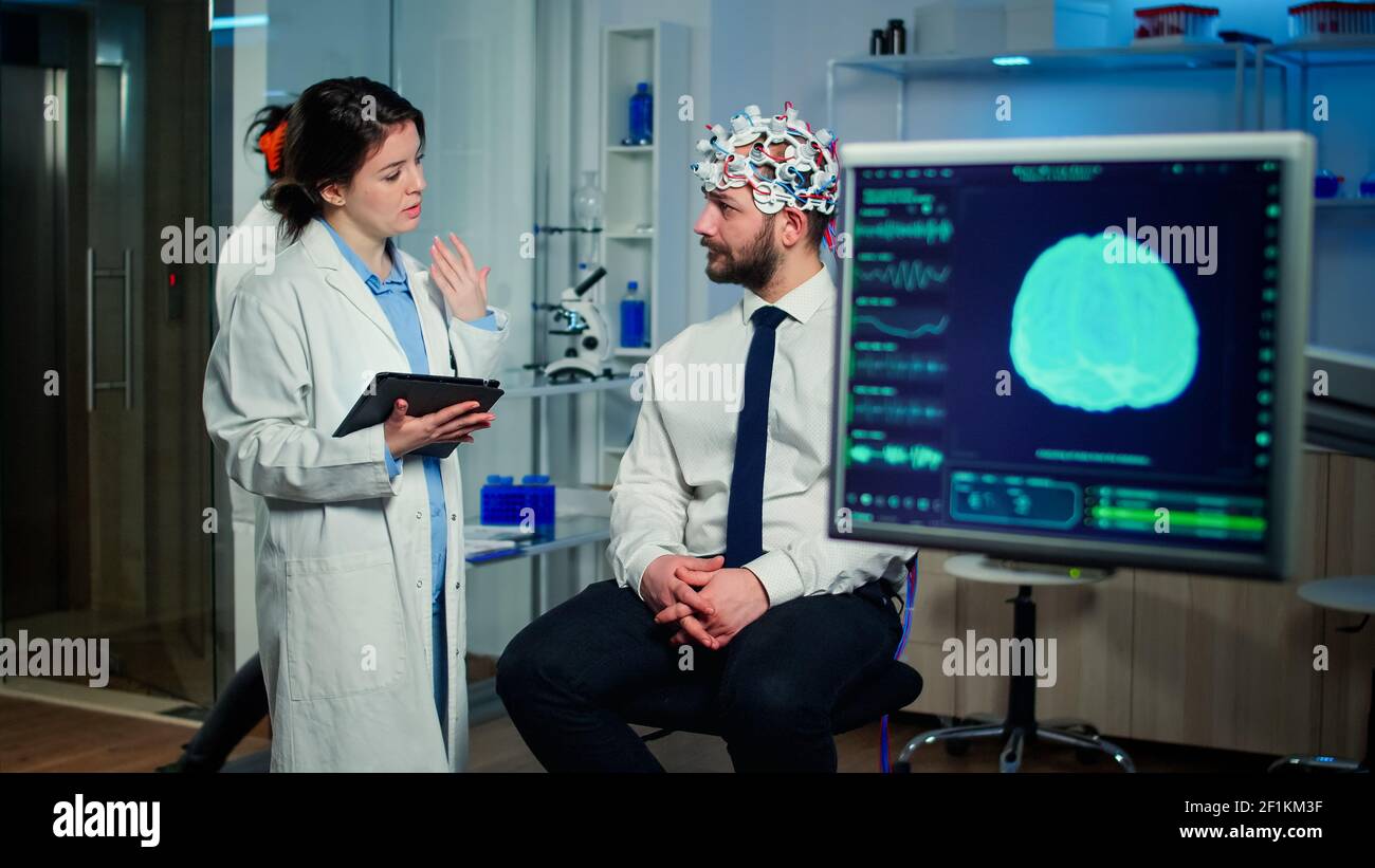 Specialist doctor in neuroscience taking notes on clipboard while ...