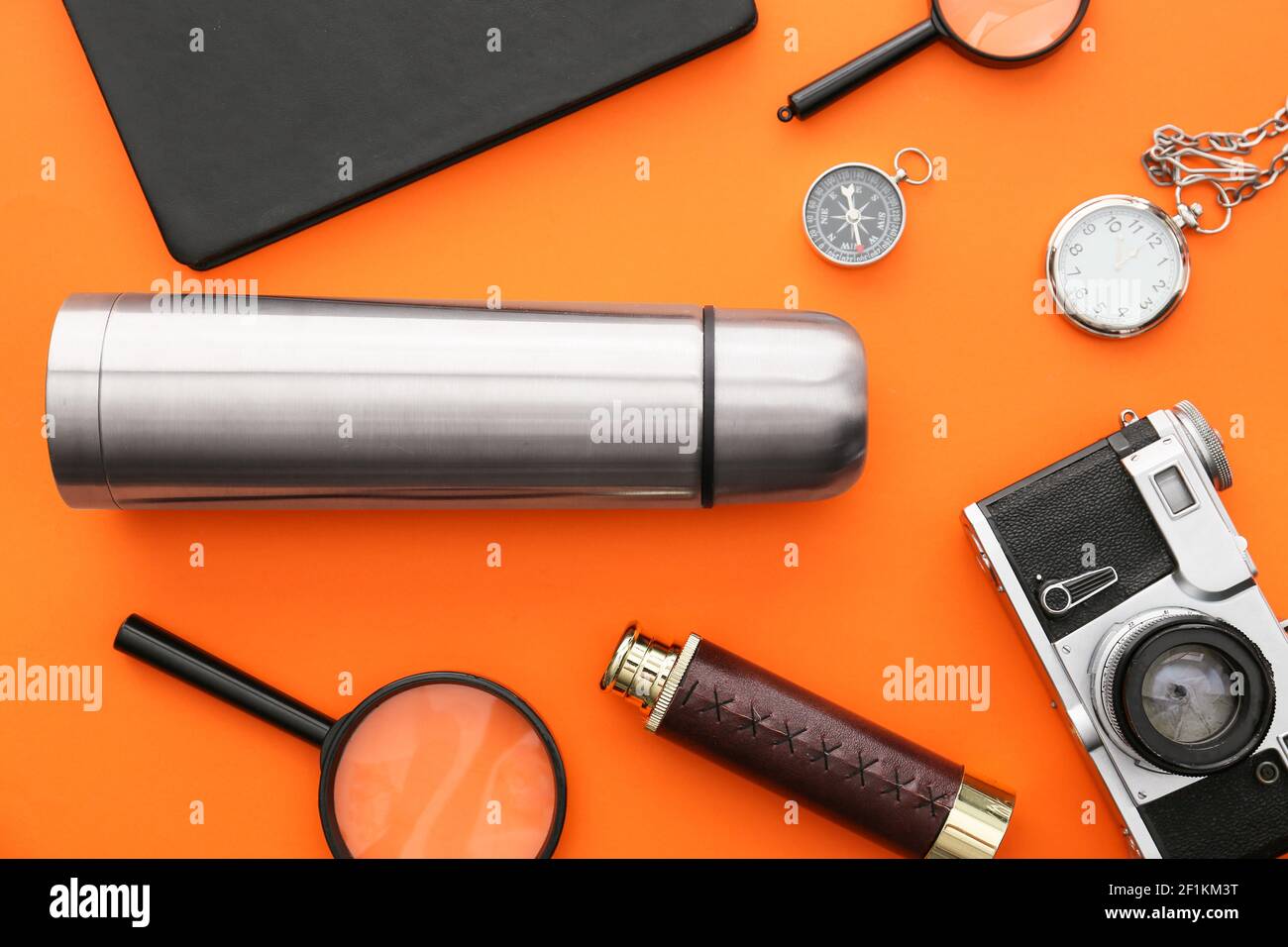 Modern thermos and items for travel on color background Stock Photo - Alamy