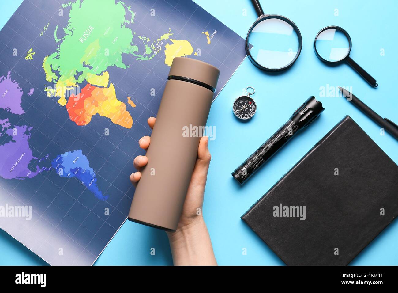 Female hand with modern thermos and world map on color background Stock ...