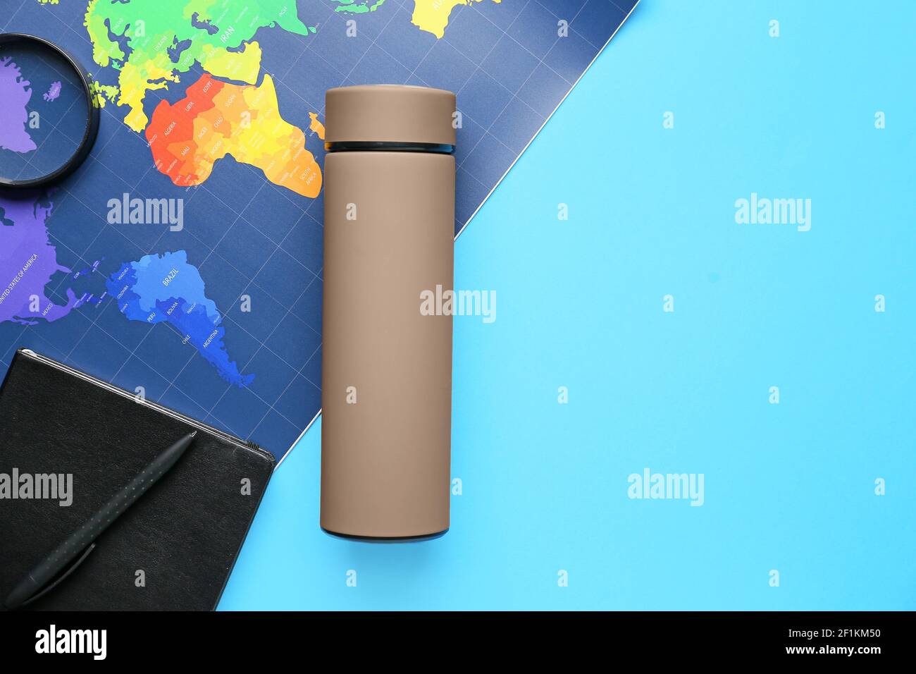 Modern thermos and world map on color background Stock Photo - Alamy