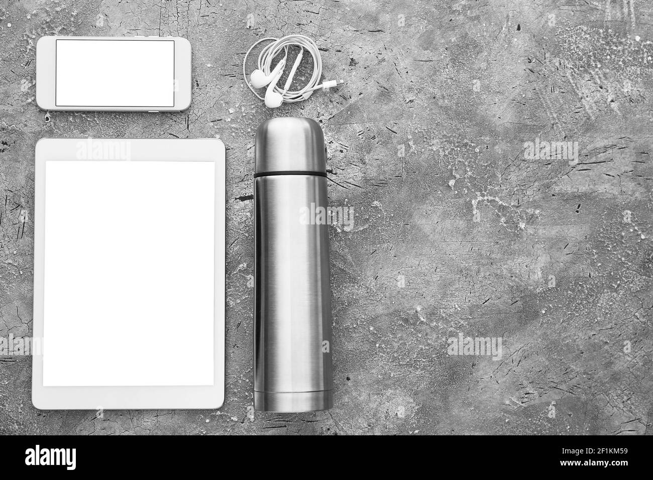 Modern thermos with gadgets on grunge background Stock Photo - Alamy