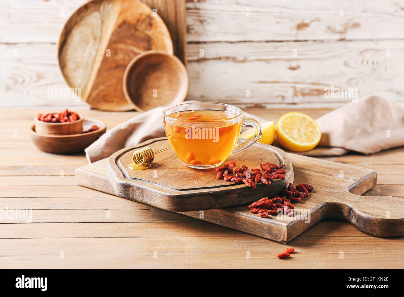Glass cup of hot tea with goji berries on light wooden background Stock ...