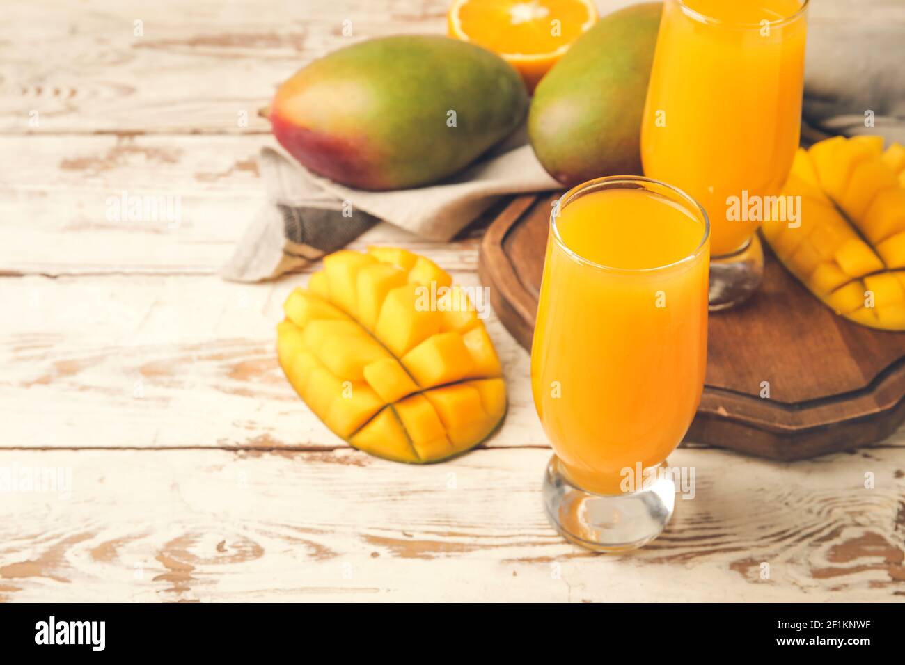 Glasses of fresh mango juice on light wooden background Stock Photo - Alamy