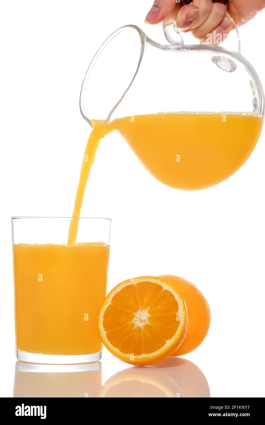 Orange juice pouring from pitcher into glass, isolated on white background Stock Photo - Alamy