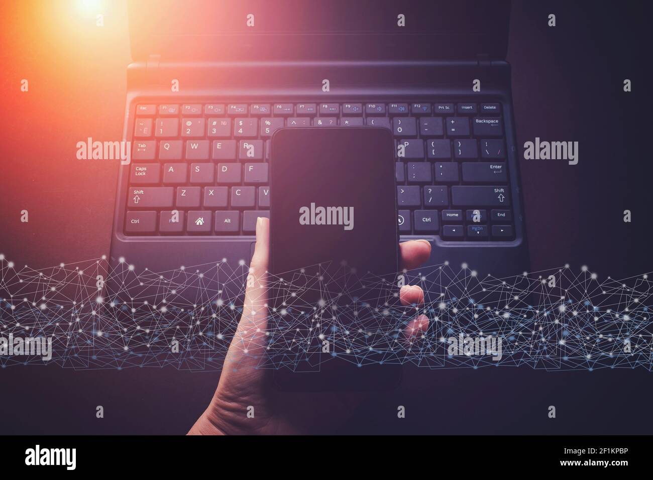 Hand Using Laptop and Mobile Phone On Table In Office with digital ...