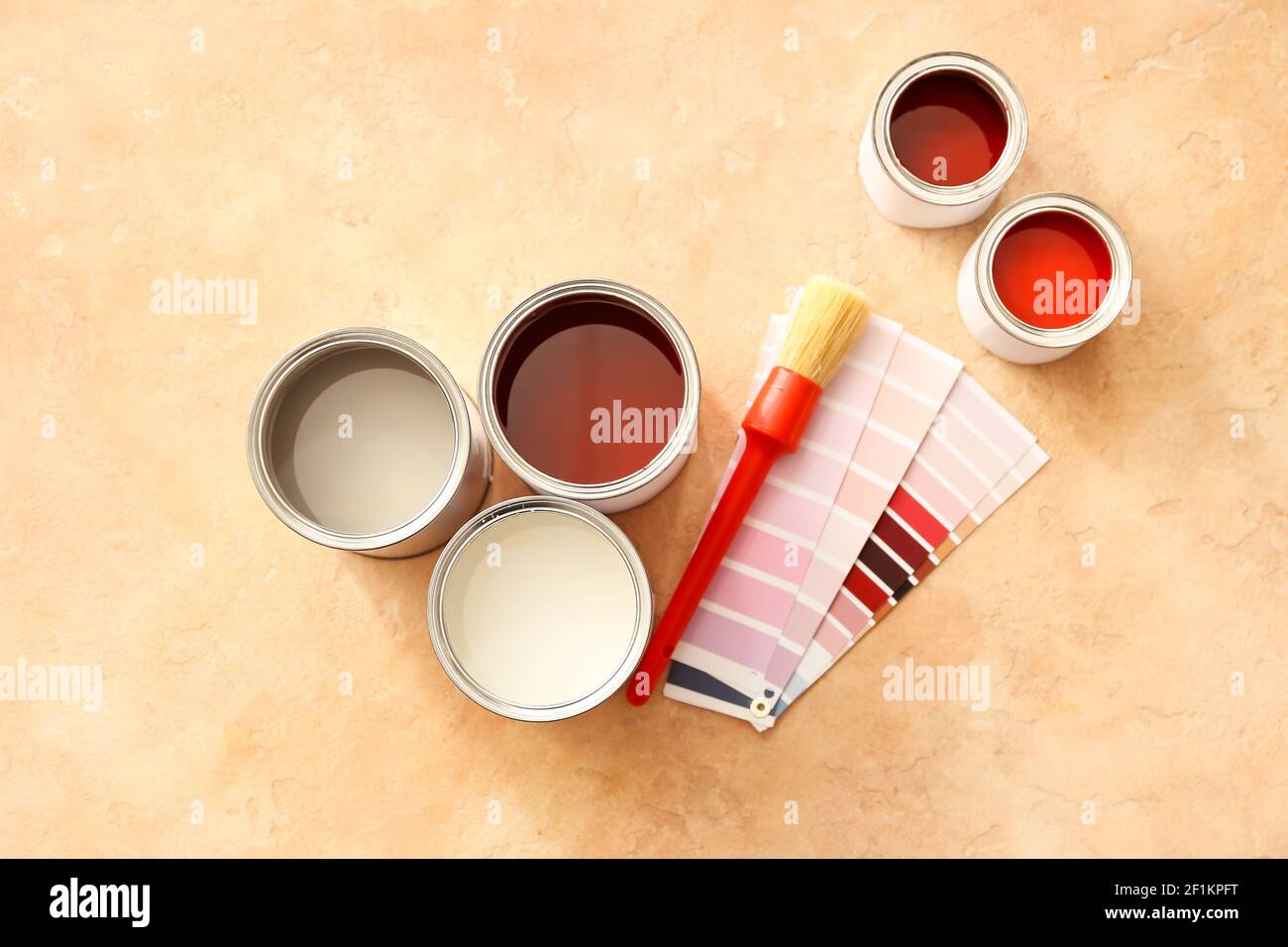 Cans of paints with palette samples and brush on color background Stock ...