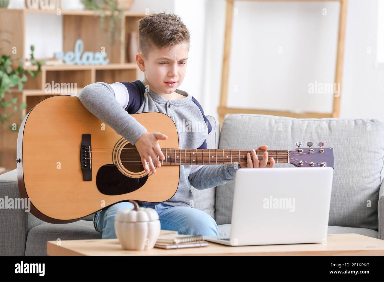 Little boy taking music lessons online at home Stock Photo - Alamy