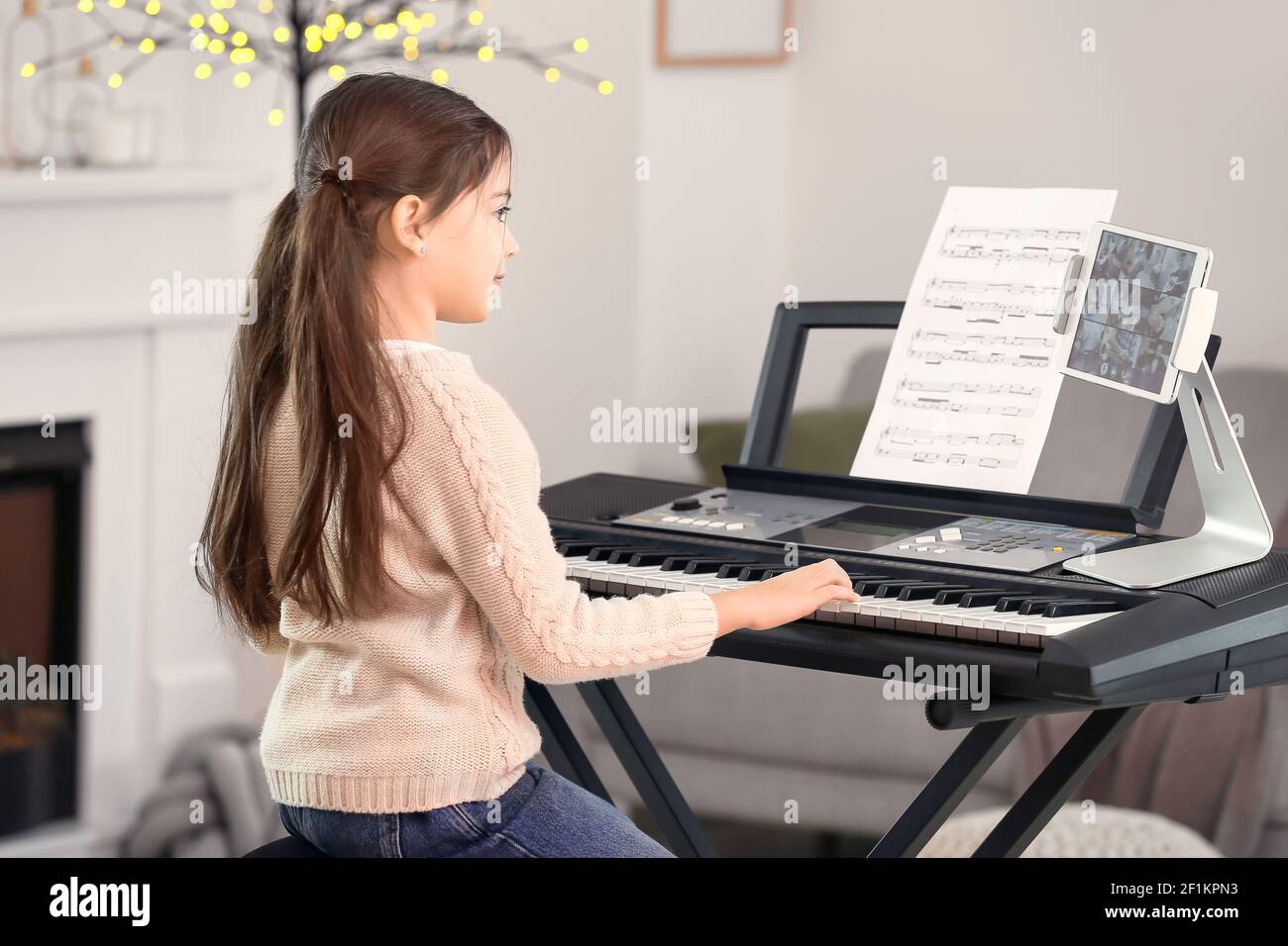 Little girl taking music lessons online at home Stock Photo - Alamy