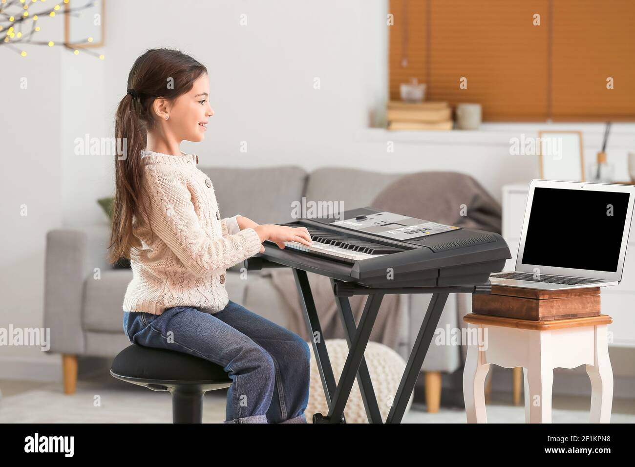 Little girl studying music with her friend online at home Stock Photo ...