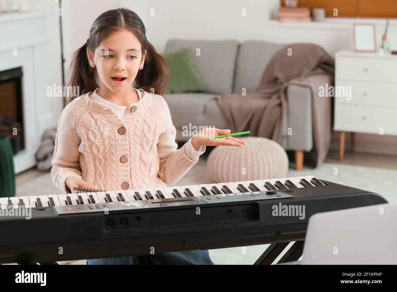 Little girl taking music lessons online at home Stock Photo - Alamy