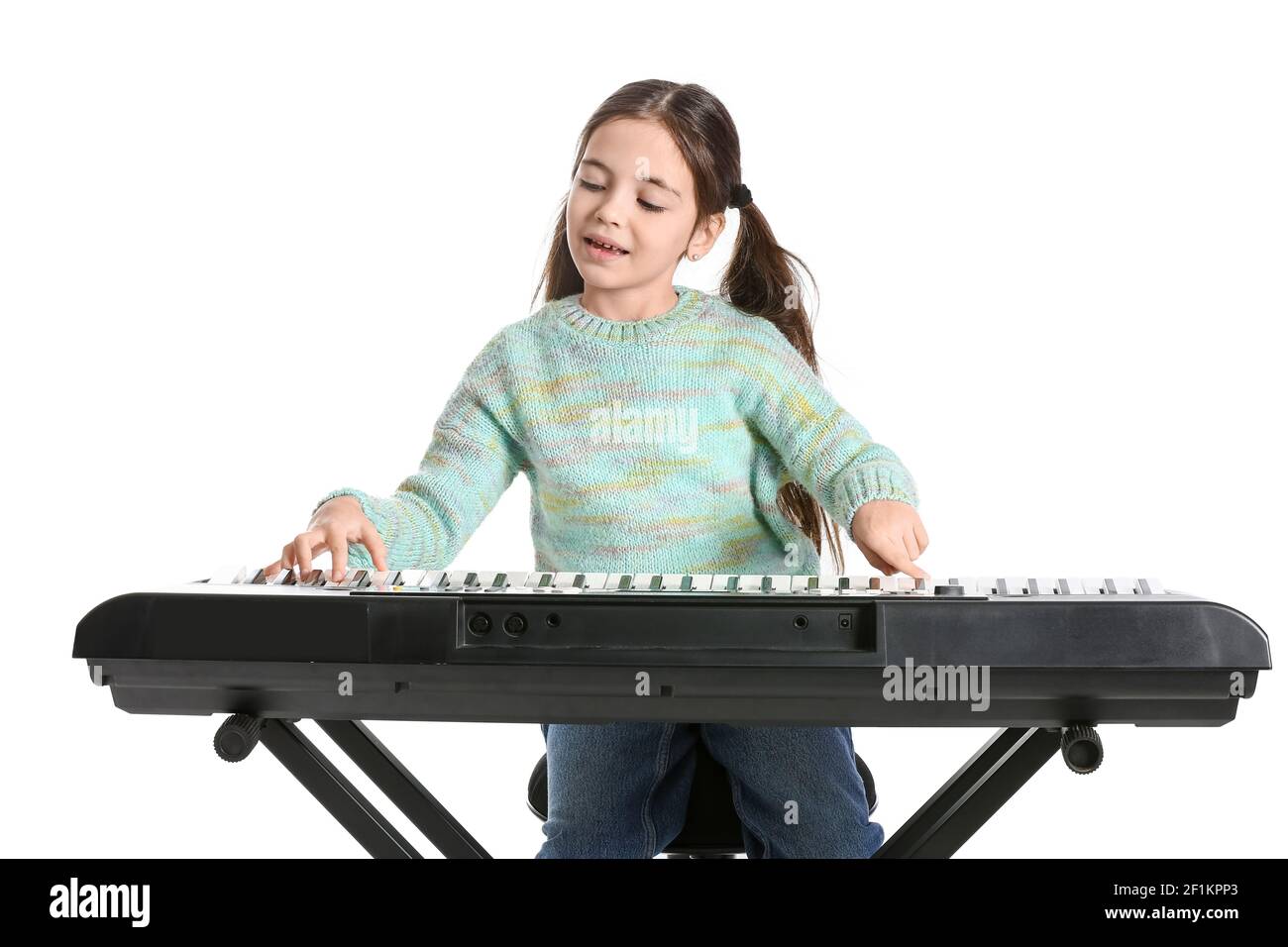 Little girl playing synthesizer on white background Stock Photo - Alamy