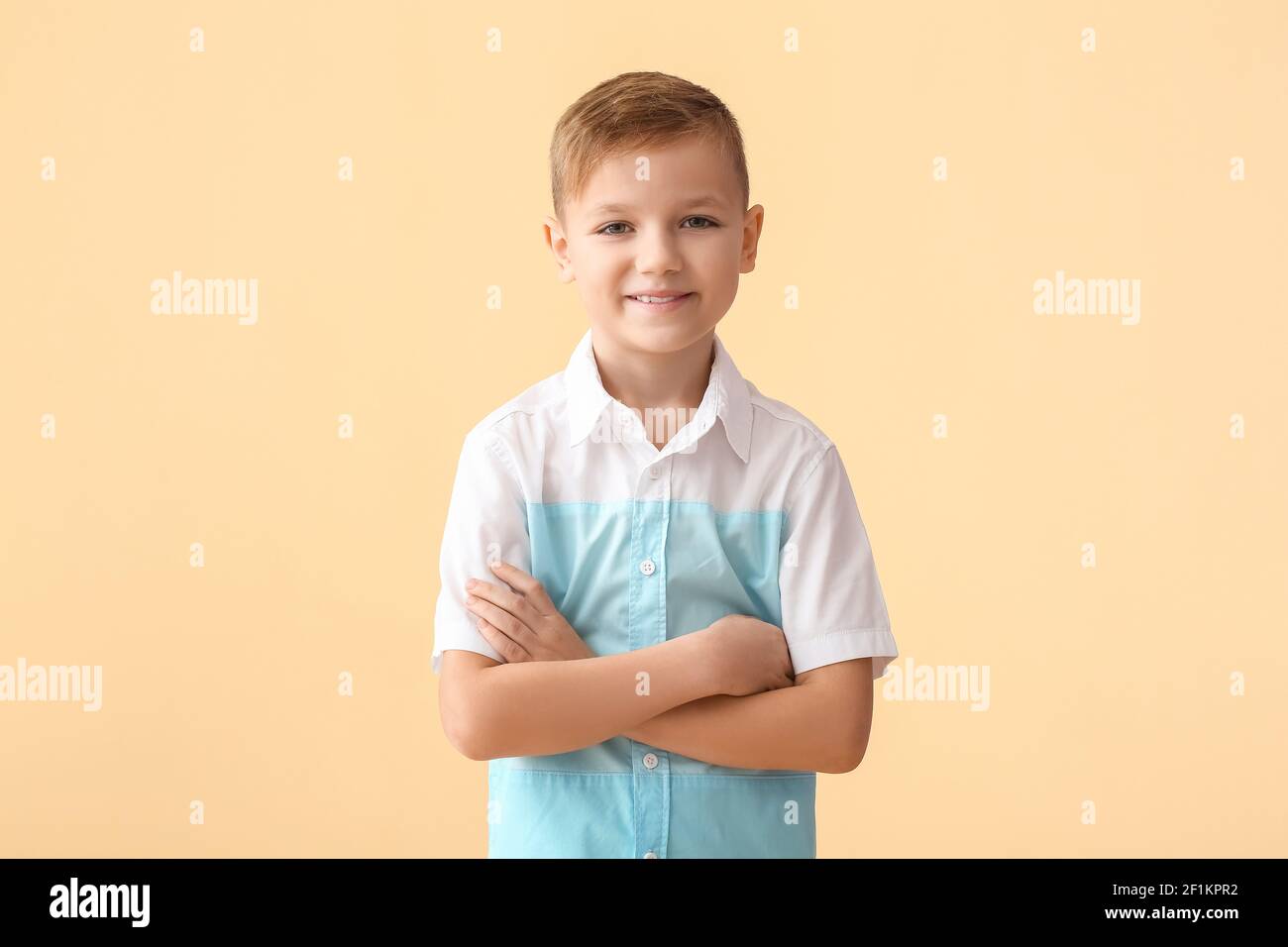 Cute little boy with crossed arms on light background Stock Photo - Alamy