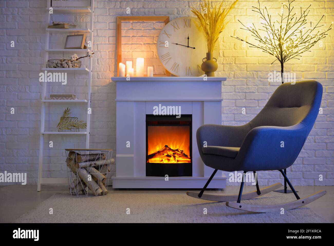 Interior of living room with fireplace in evening Stock Photo - Alamy