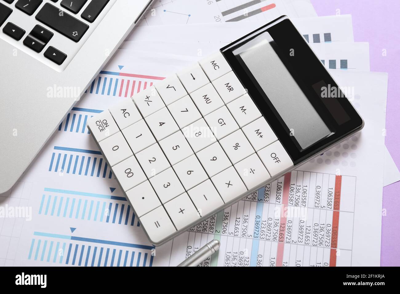 Modern calculator and documents with laptop on color background Stock ...