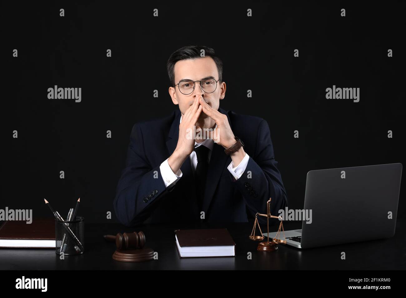 Male judge at table on dark background Stock Photo - Alamy