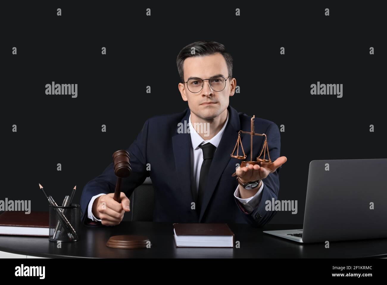 Male judge at table on dark background Stock Photo - Alamy