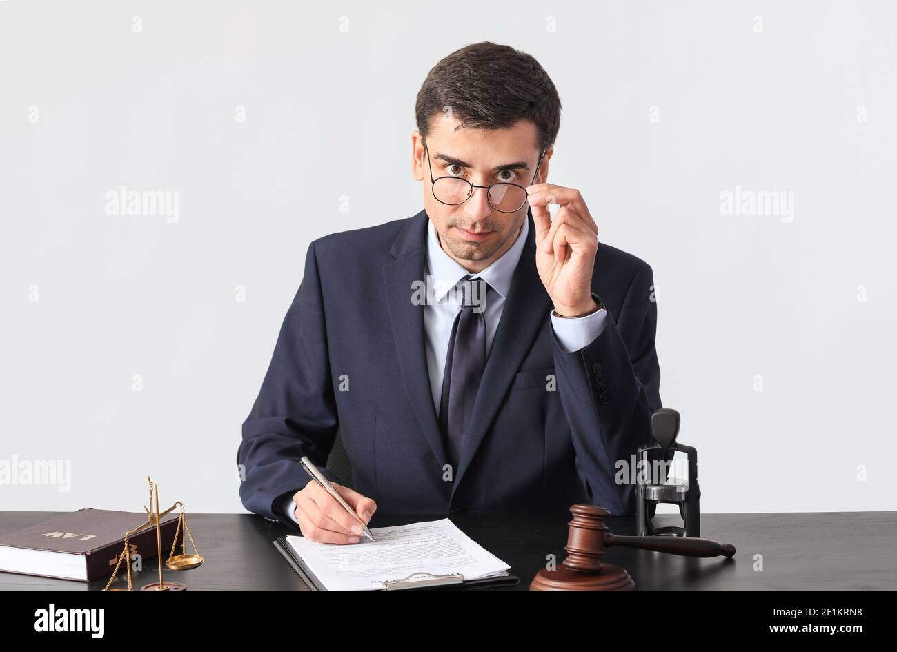 Male judge at table on grey background Stock Photo - Alamy