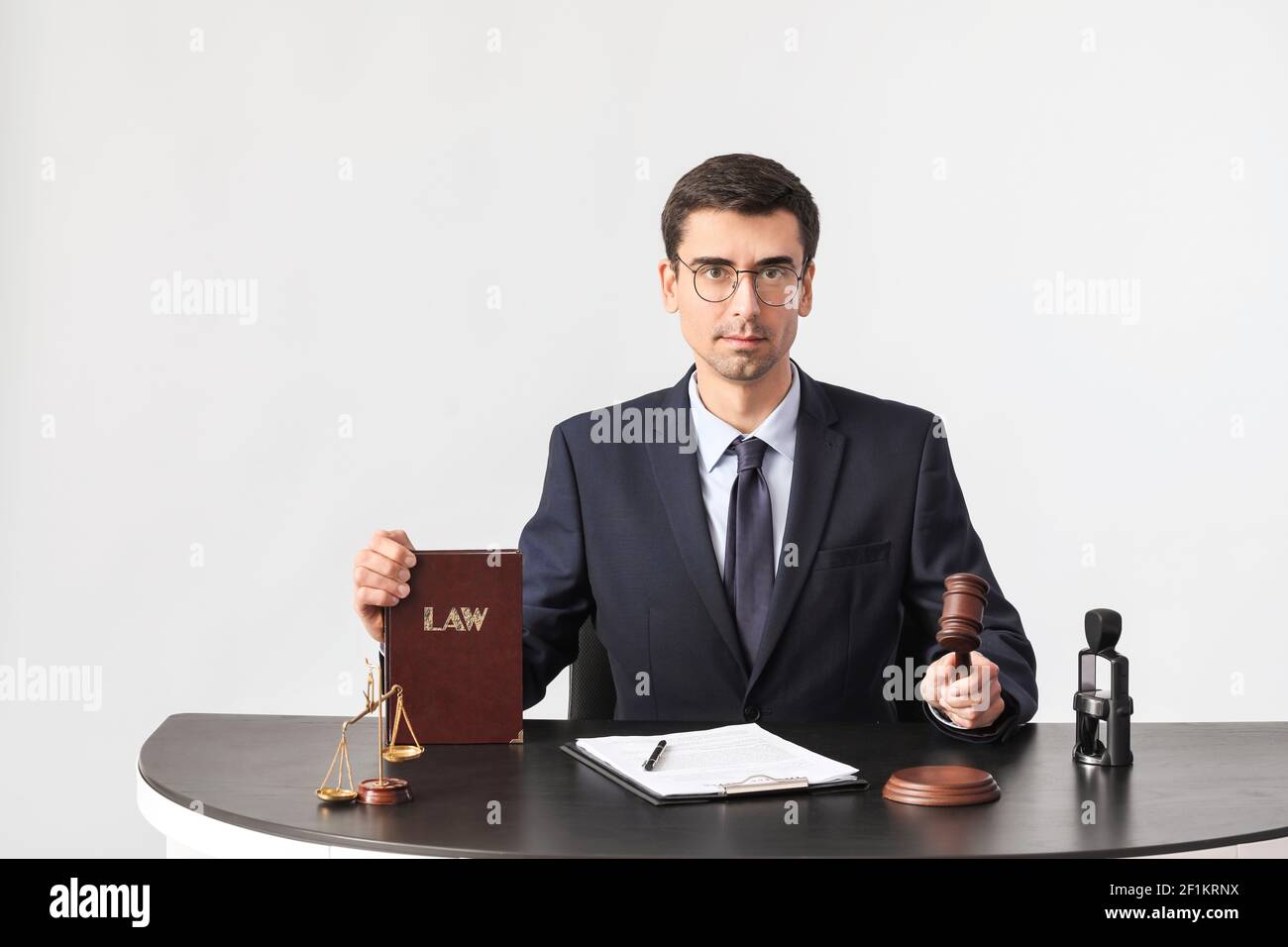 Male judge at table on grey background Stock Photo - Alamy