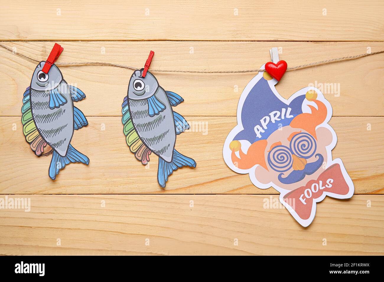 Paper fishes and greeting card on wooden background. April Fools Day ...