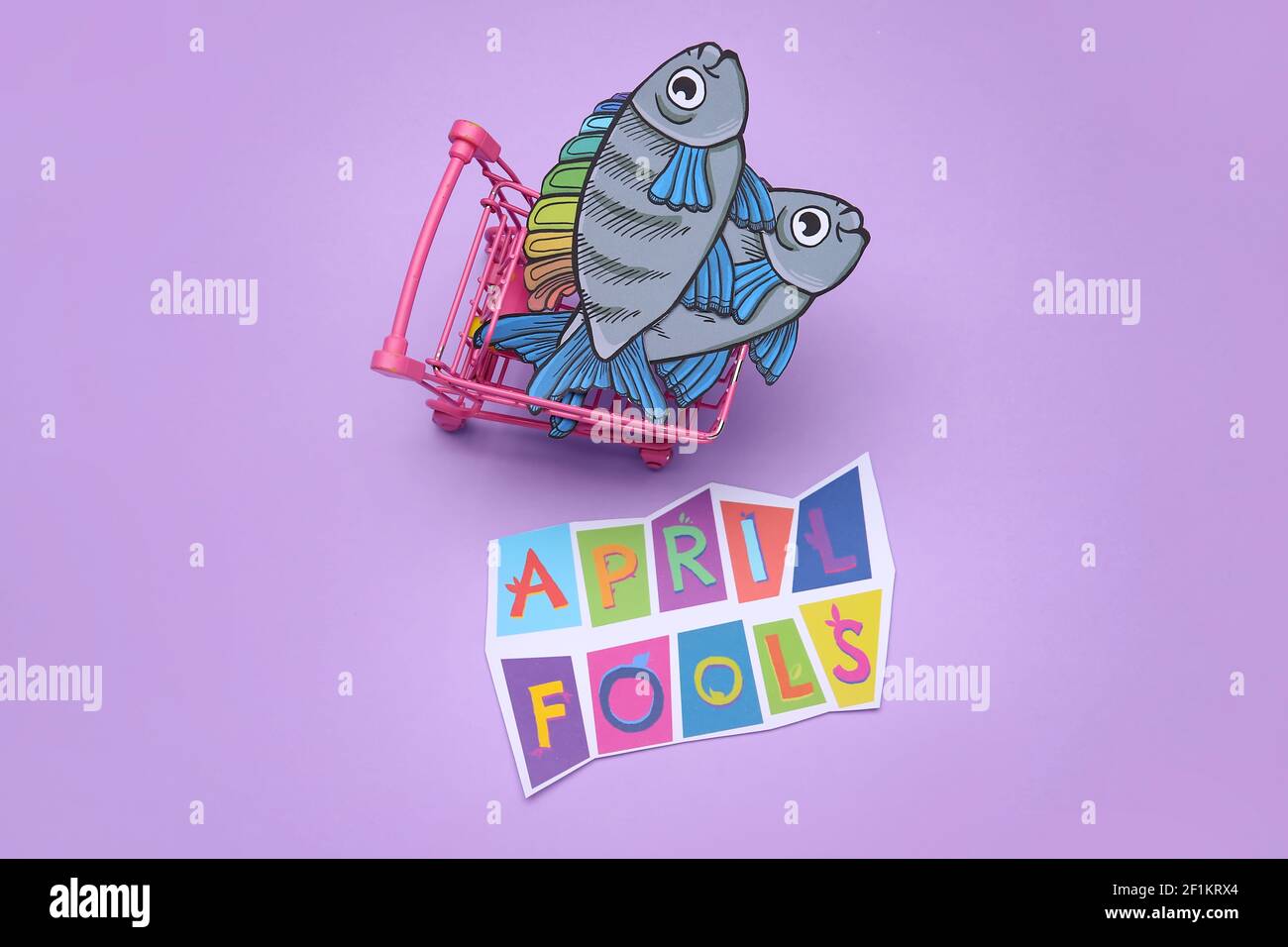 Shopping basket with paper fishes on color background. April Fools Day ...
