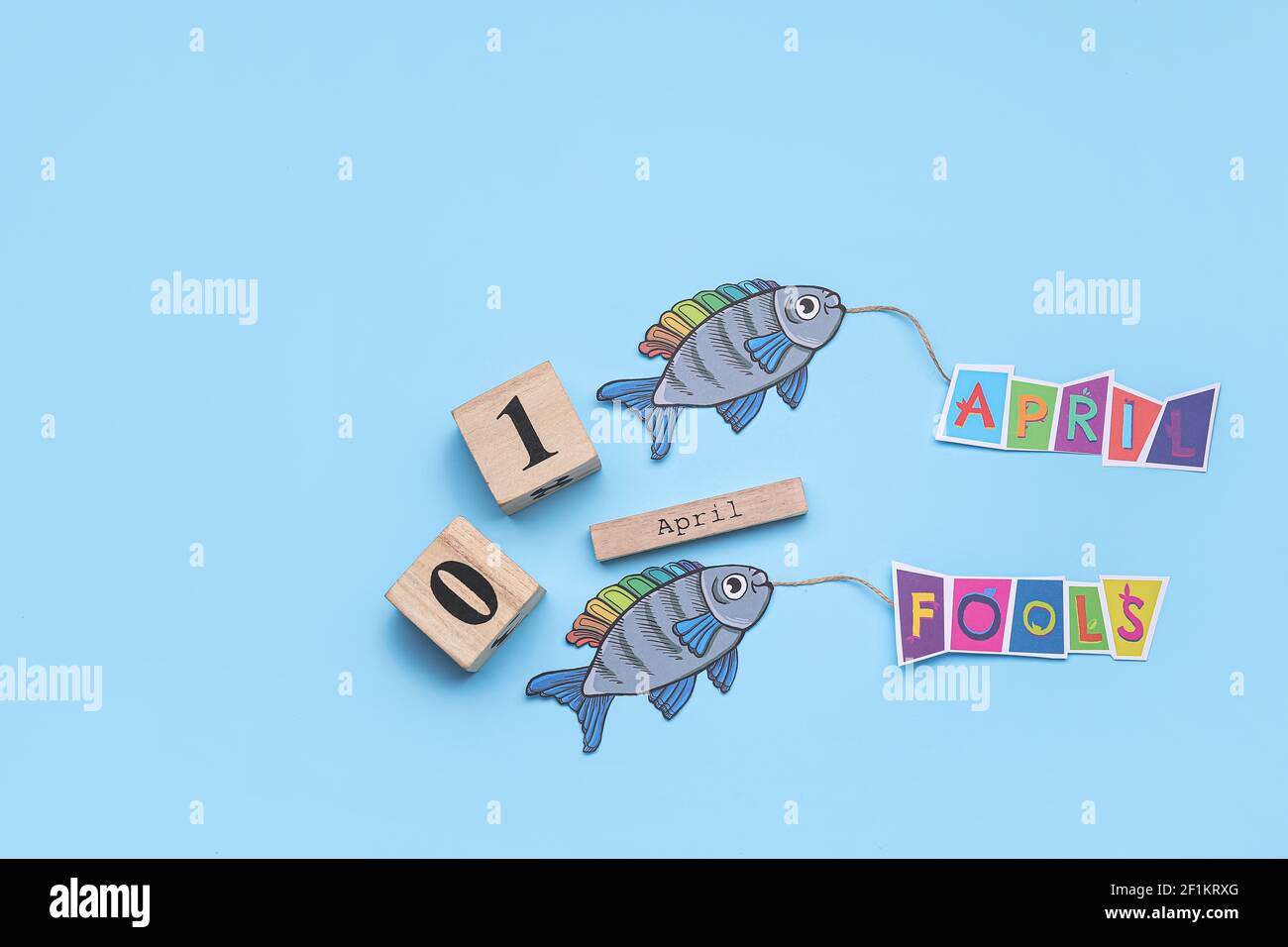 Paper fishes and calendar with date of April Fools Day on color ...
