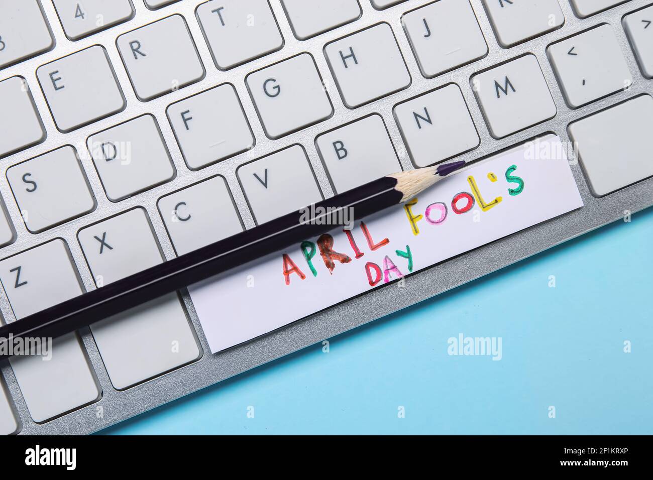 Computer keyboard with pencil and text APRIL FOOL'S Day on color ...