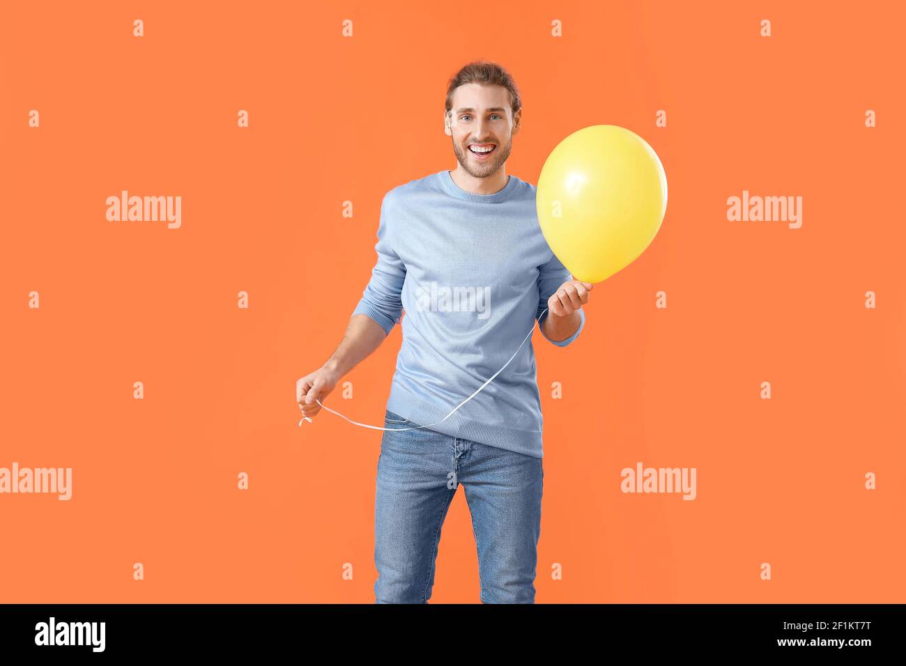 Handsome young man with balloon on color background Stock Photo - Alamy