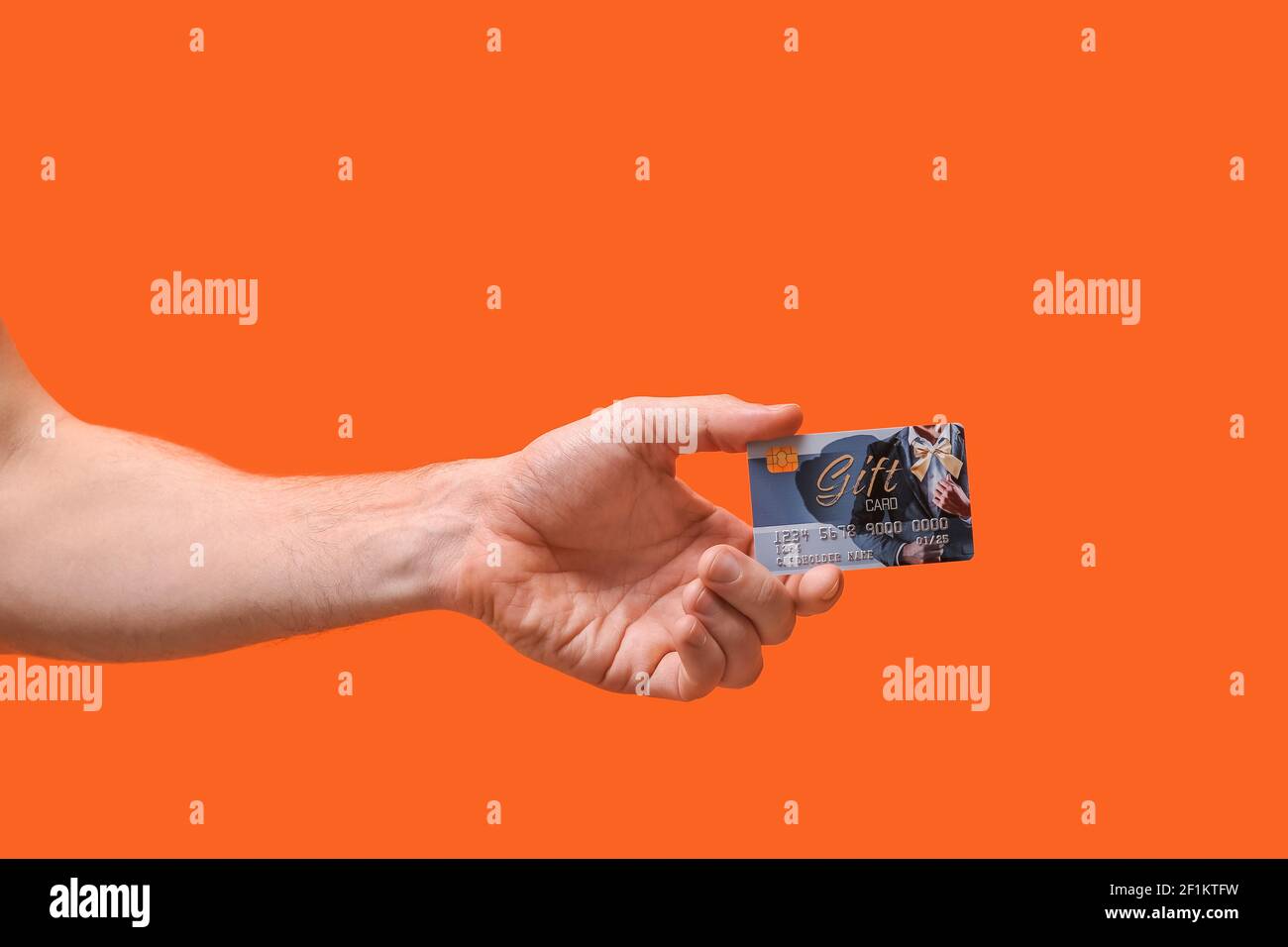 Hand with gift card on color background Stock Photo - Alamy