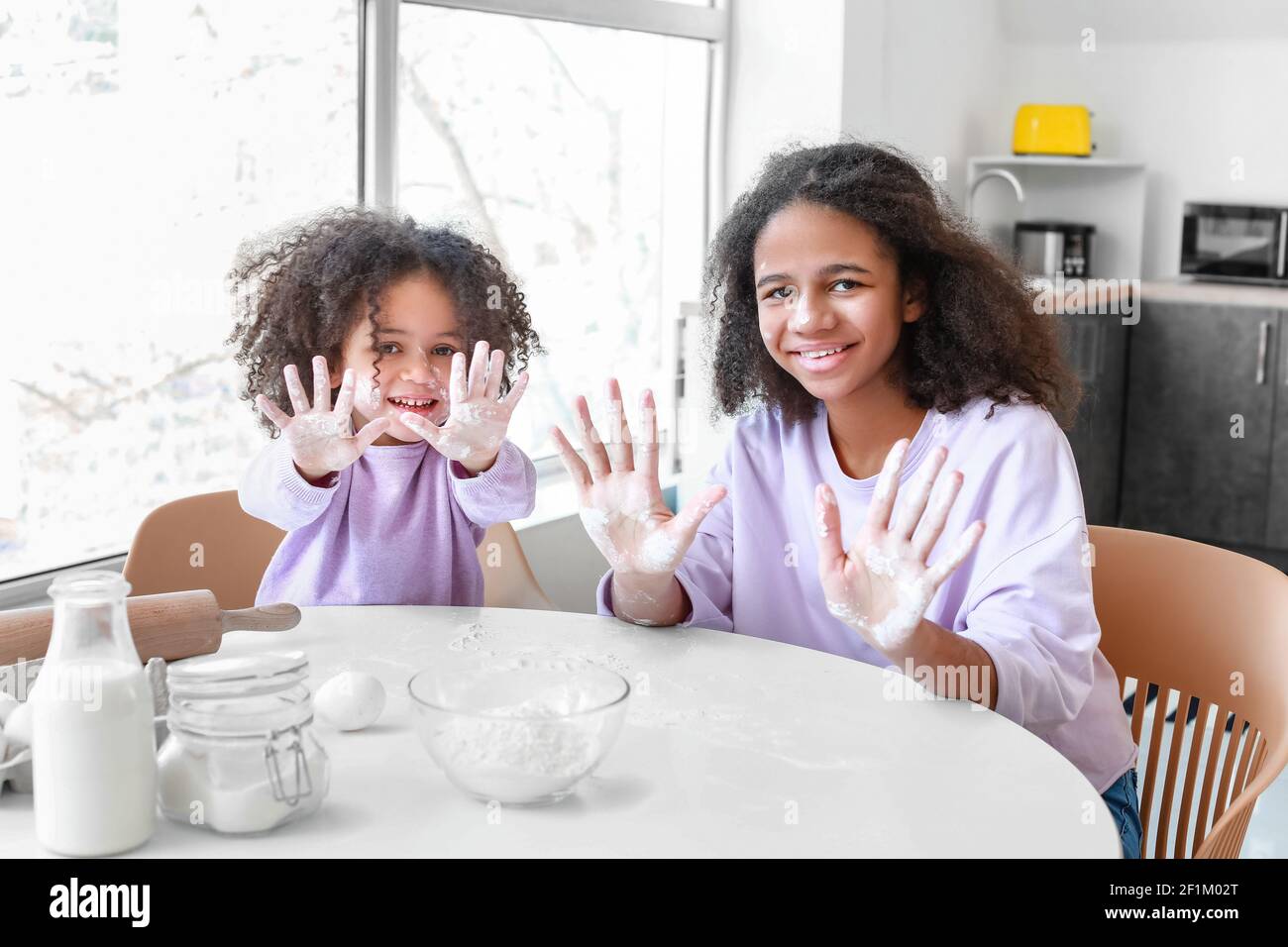 Cute African-American sisters cooking in kitchen Stock Photo - Alamy