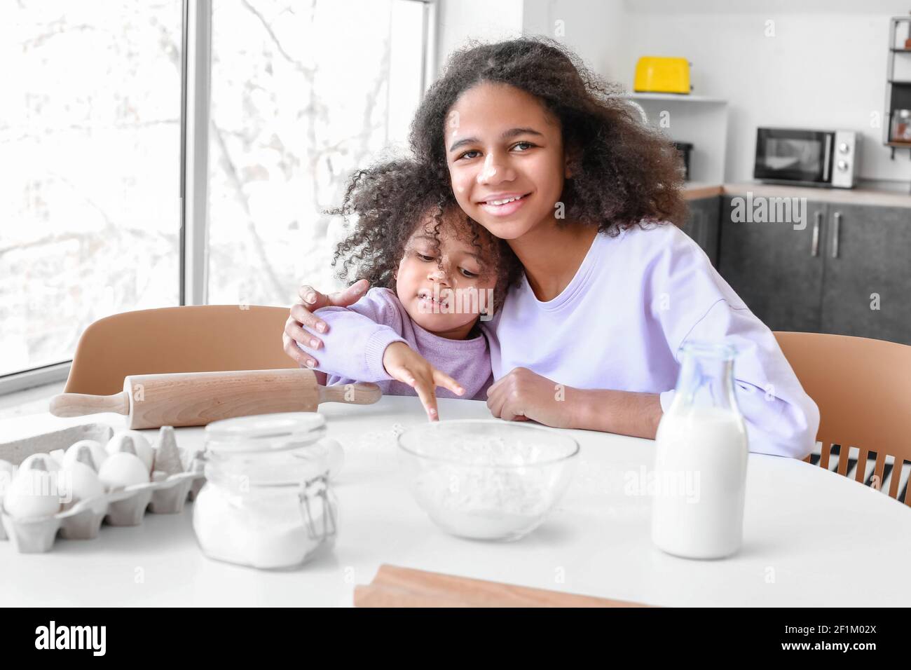 Cute African-American sisters cooking in kitchen Stock Photo - Alamy