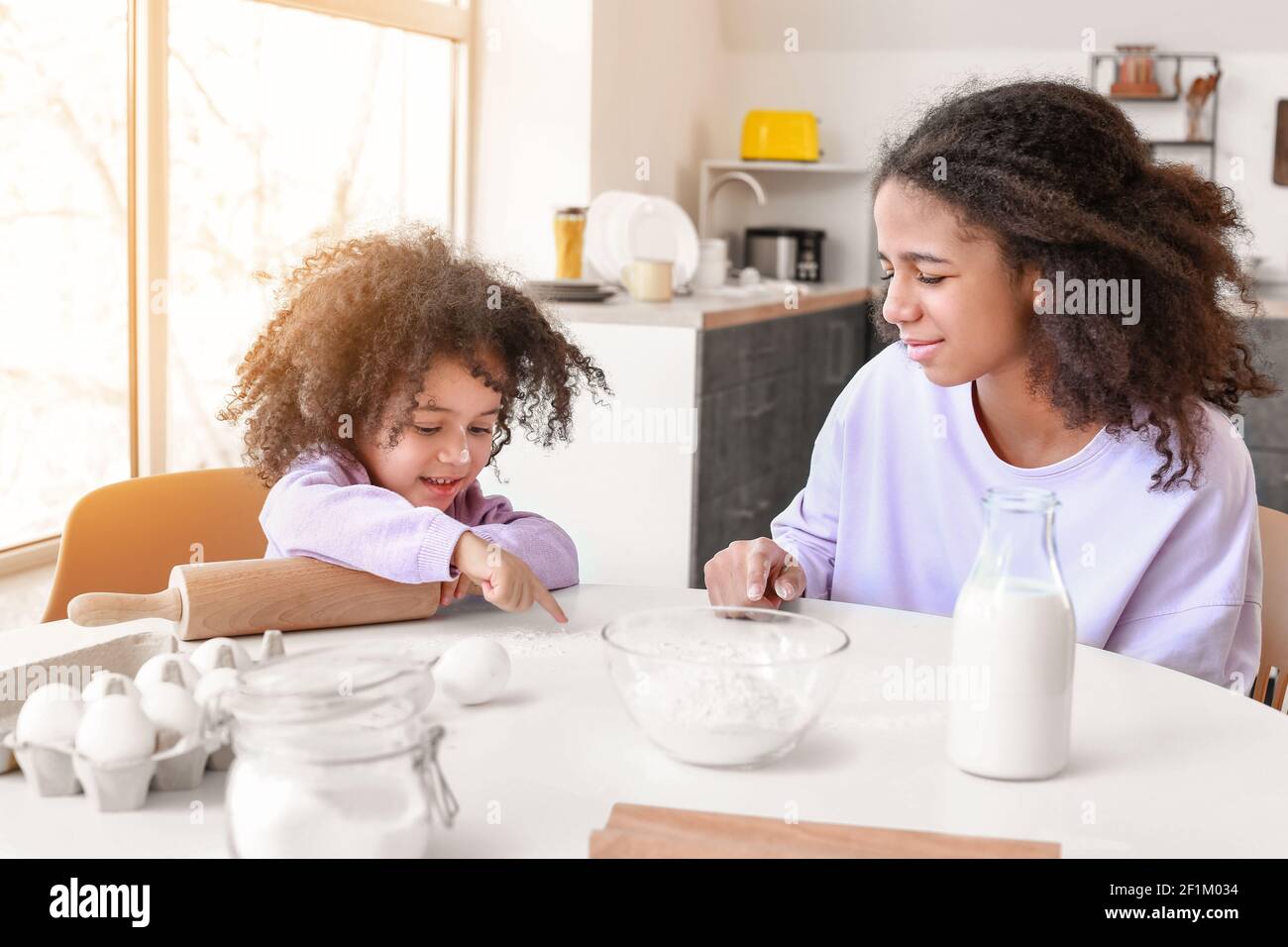 Cute African-American sisters cooking in kitchen Stock Photo - Alamy