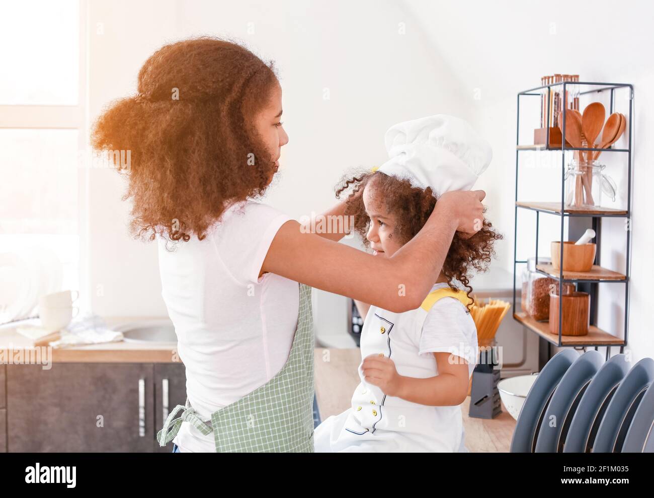 Cute African-American sisters cooking in kitchen Stock Photo - Alamy