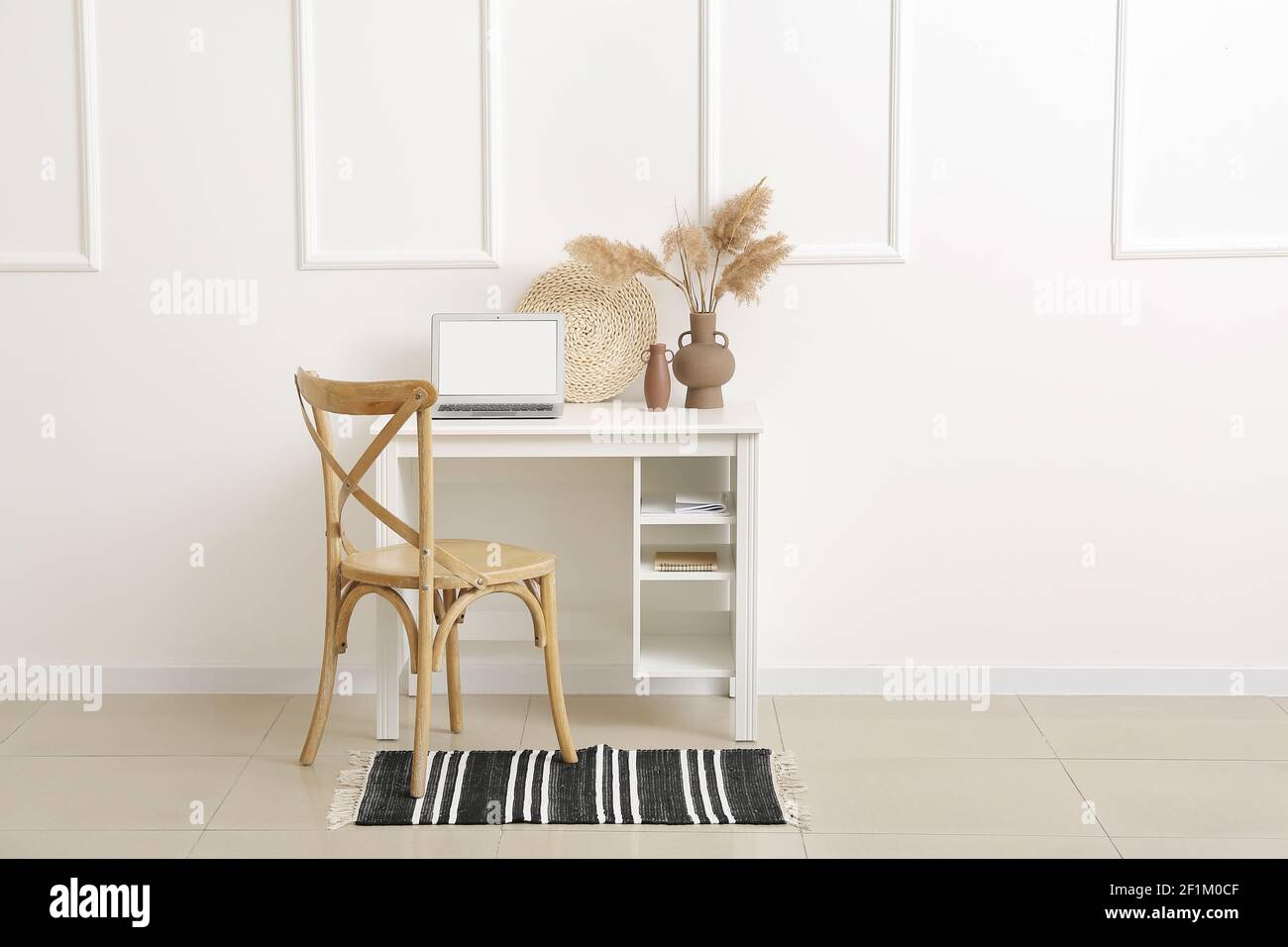 Comfortable workplace near light wall in room Stock Photo - Alamy
