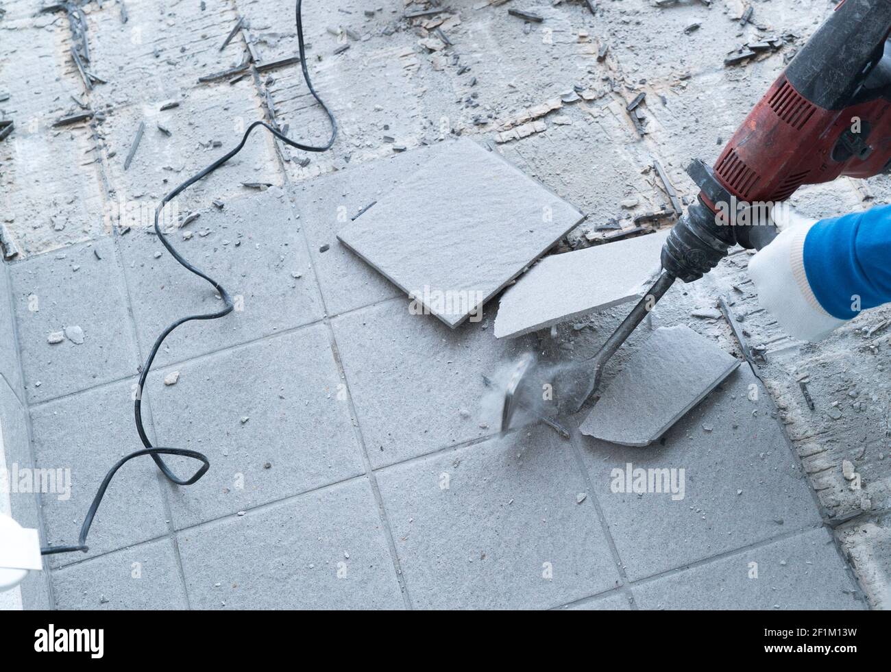 Construction worker using a handheld demolition hammer and wall breaker ...