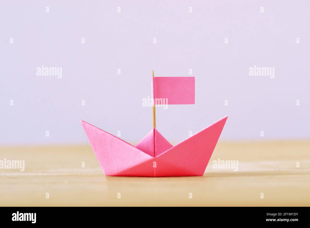 Pink paper boat with flag - Concept of women's leadership Stock Photo ...