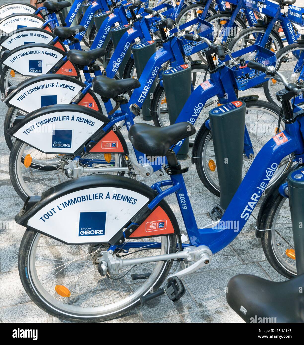 Bike rental station with many blue and white bikes in the city of ...