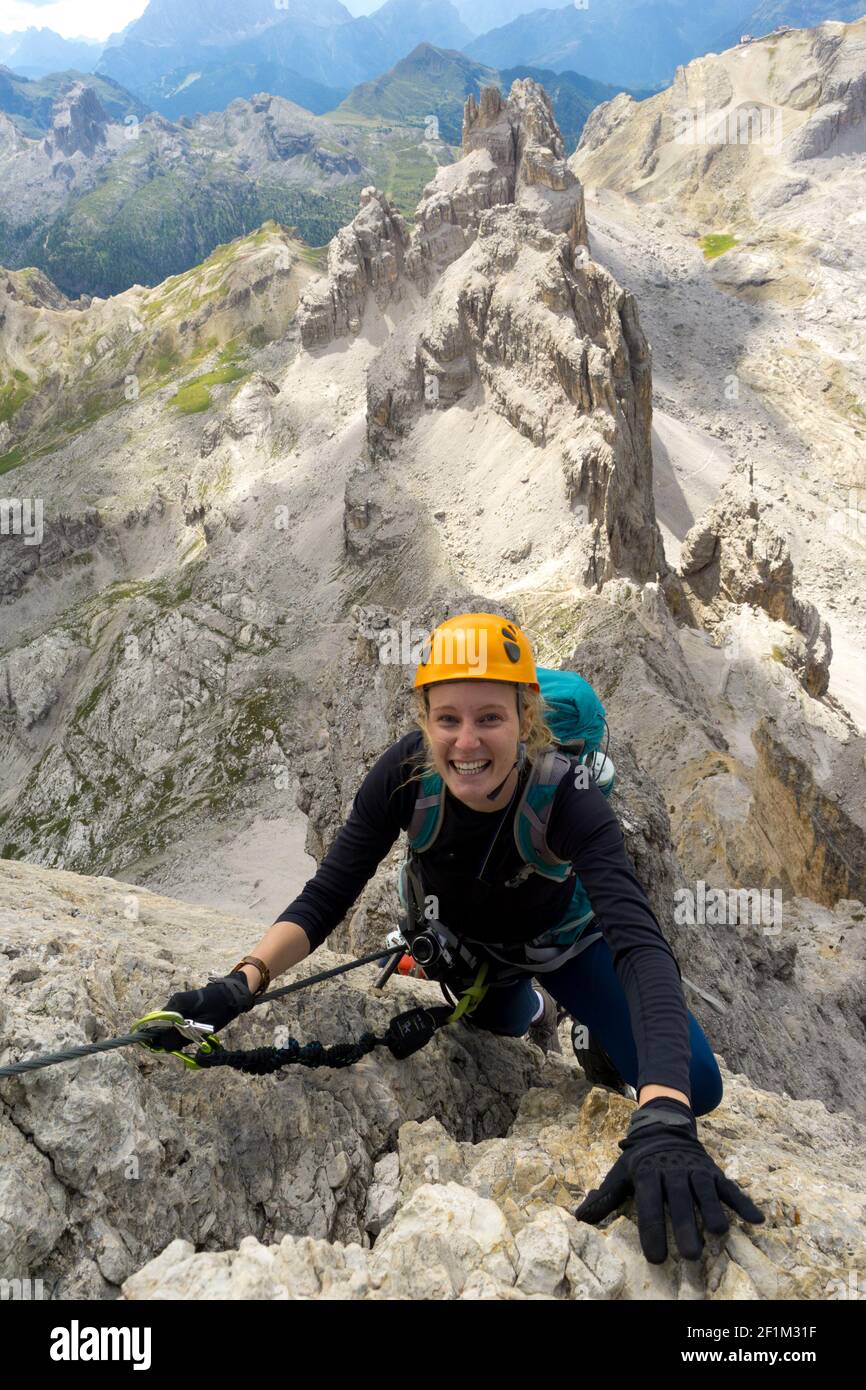 Attractive female climber on a steep Via Ferrata in the Italian ...