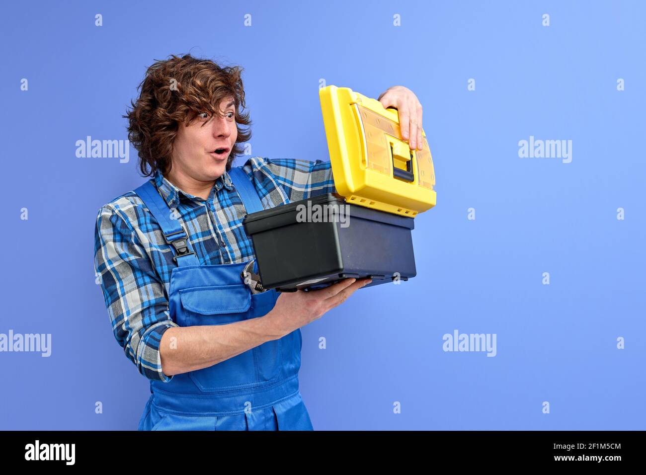 builder man opening tools box with shocked expression on face, curly ...