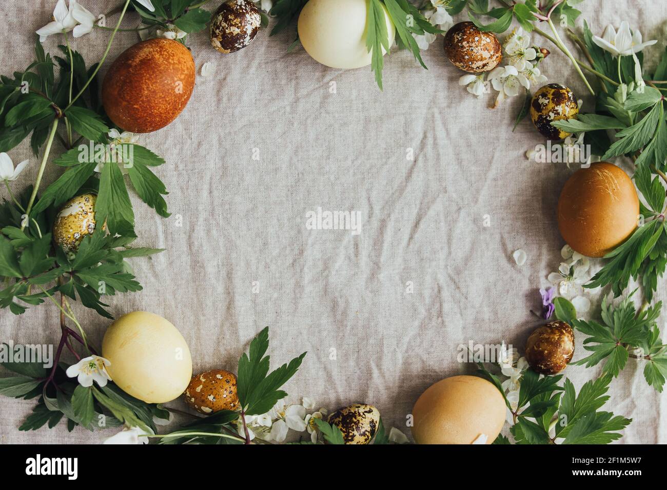 Easter rustic frame flat lay, eggs and spring flowers on rustic linen ...