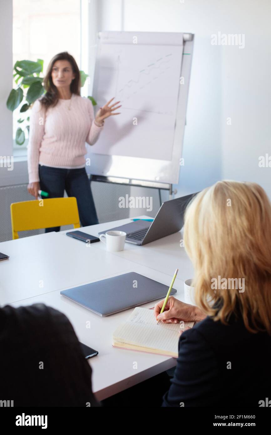 Woman taking notes during business presentation Stock Photo - Alamy