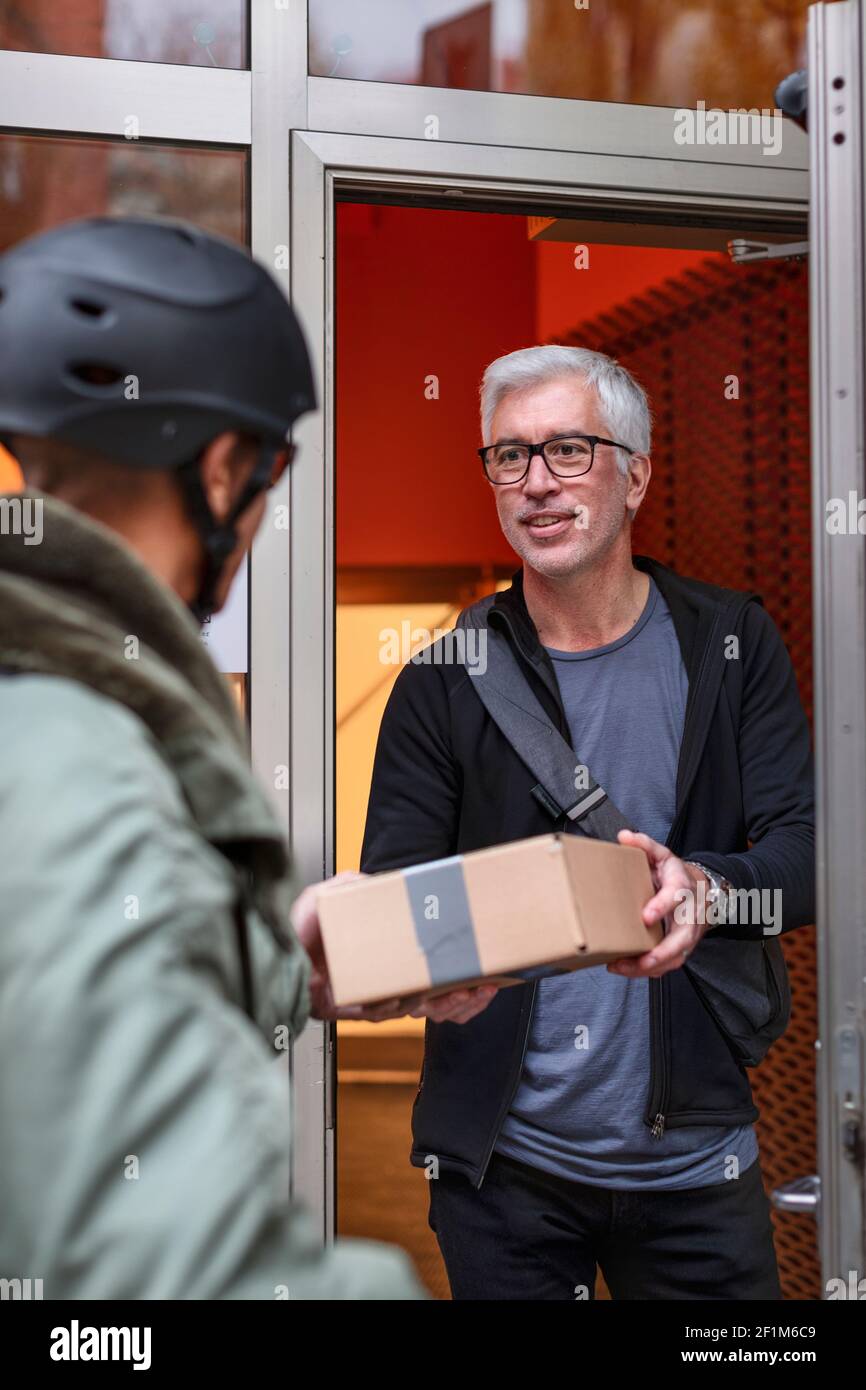 Bicycle courier delivering parcel Stock Photo - Alamy