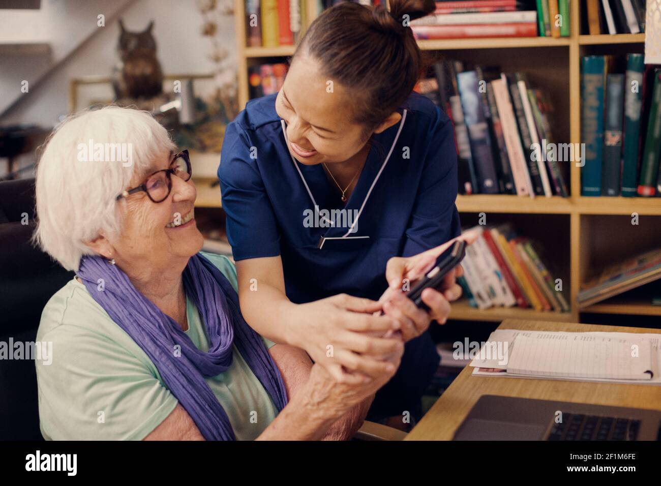 Senior woman and caregiver using cell phone Stock Photo - Alamy